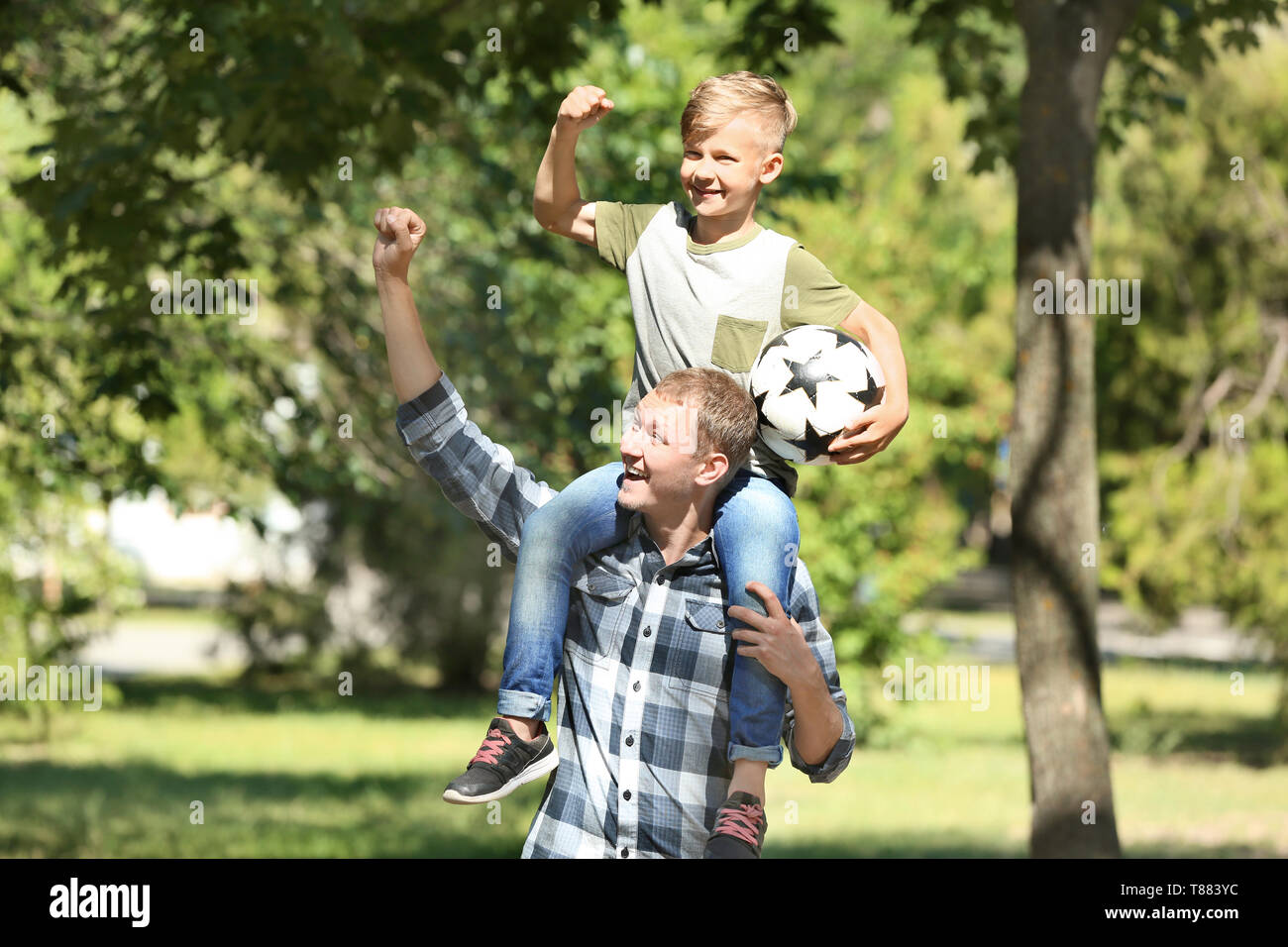 Happy father and son with soccer ball in park Stock Photo - Alamy