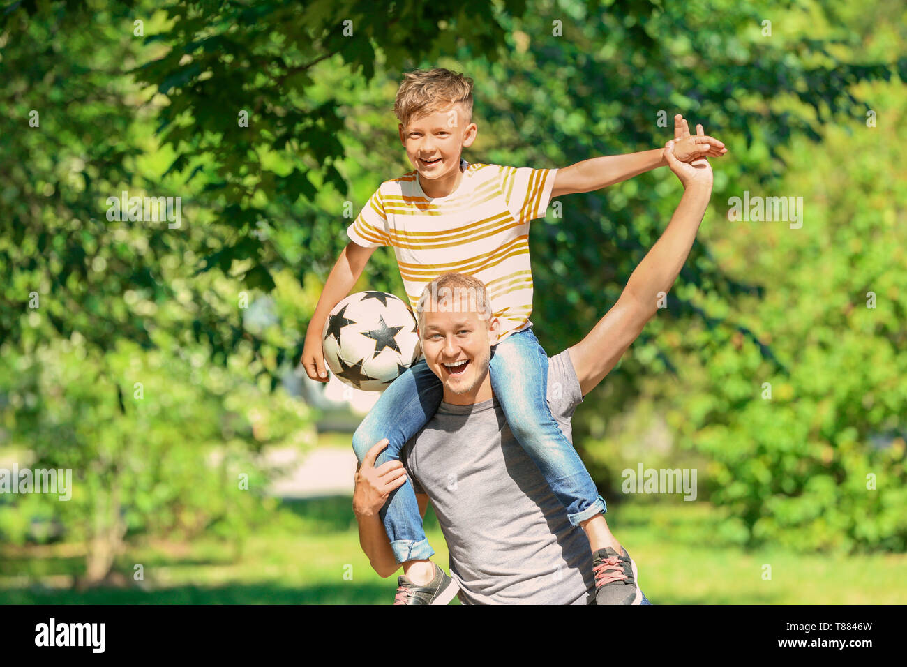 Happy father and son with soccer ball in park Stock Photo - Alamy