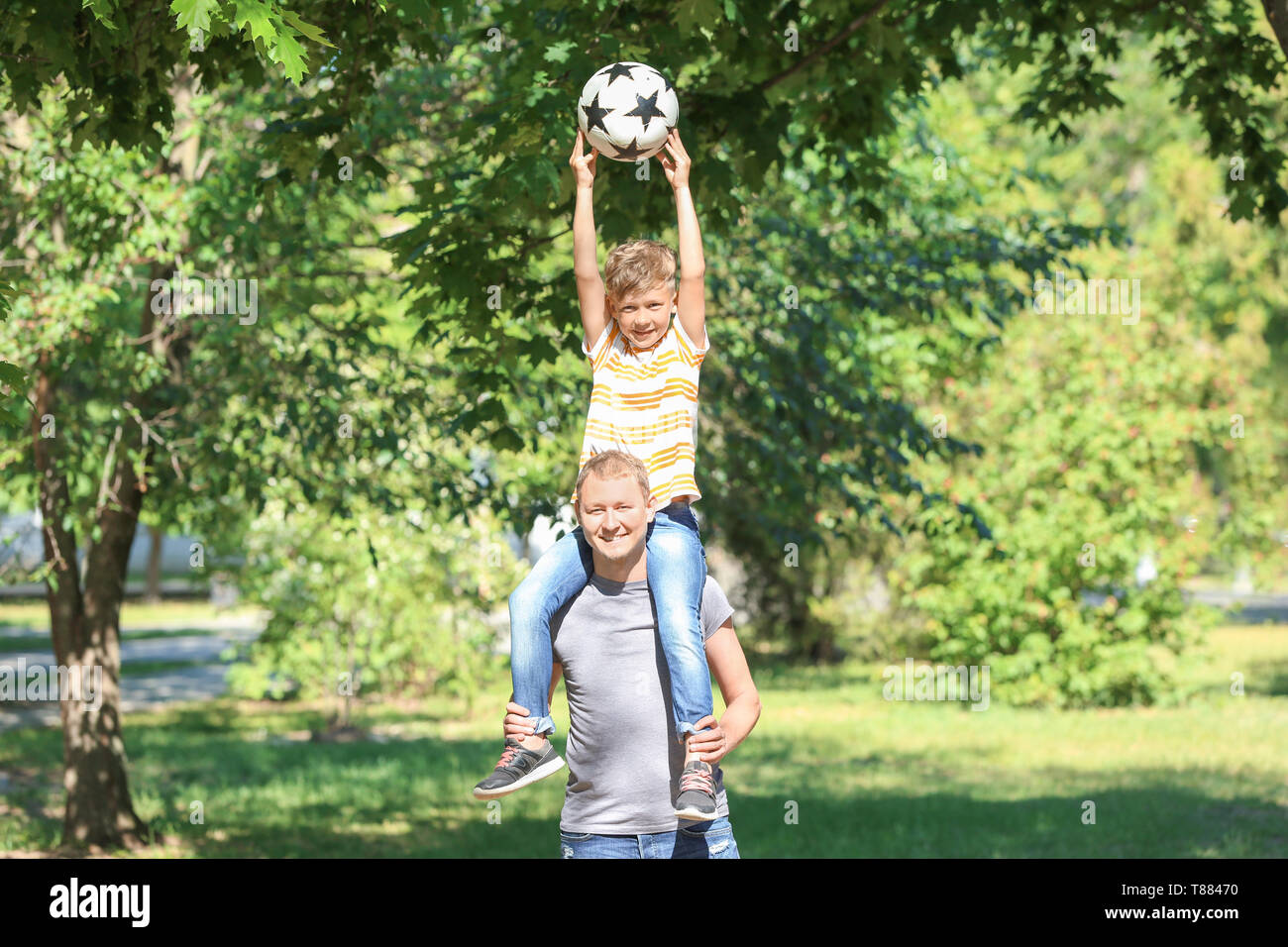 Happy father and son with soccer ball in park Stock Photo - Alamy