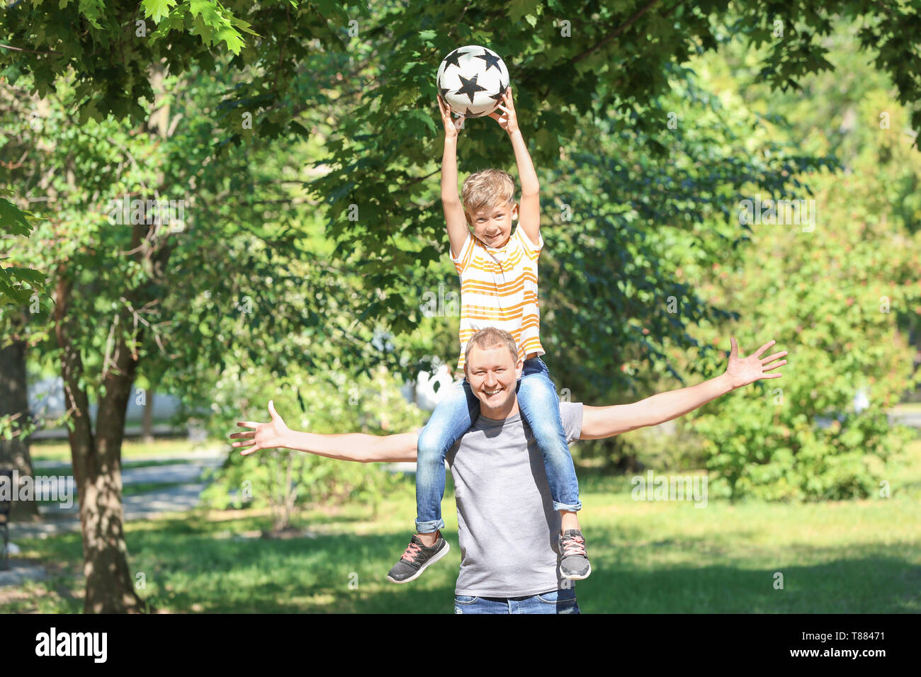 Happy father and son with soccer ball in park Stock Photo - Alamy