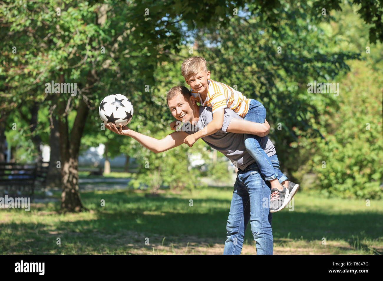 Happy father and son with soccer ball in park Stock Photo - Alamy