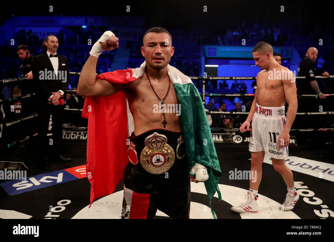 Enrique Tinoco (centre) poses for a photo after his victory over Jordan Gill (right) in the WBA ...