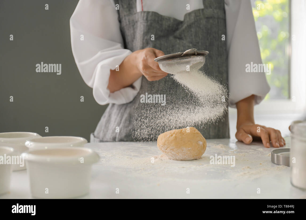 Baker pouring flour on dough hi-res stock photography and images - Alamy