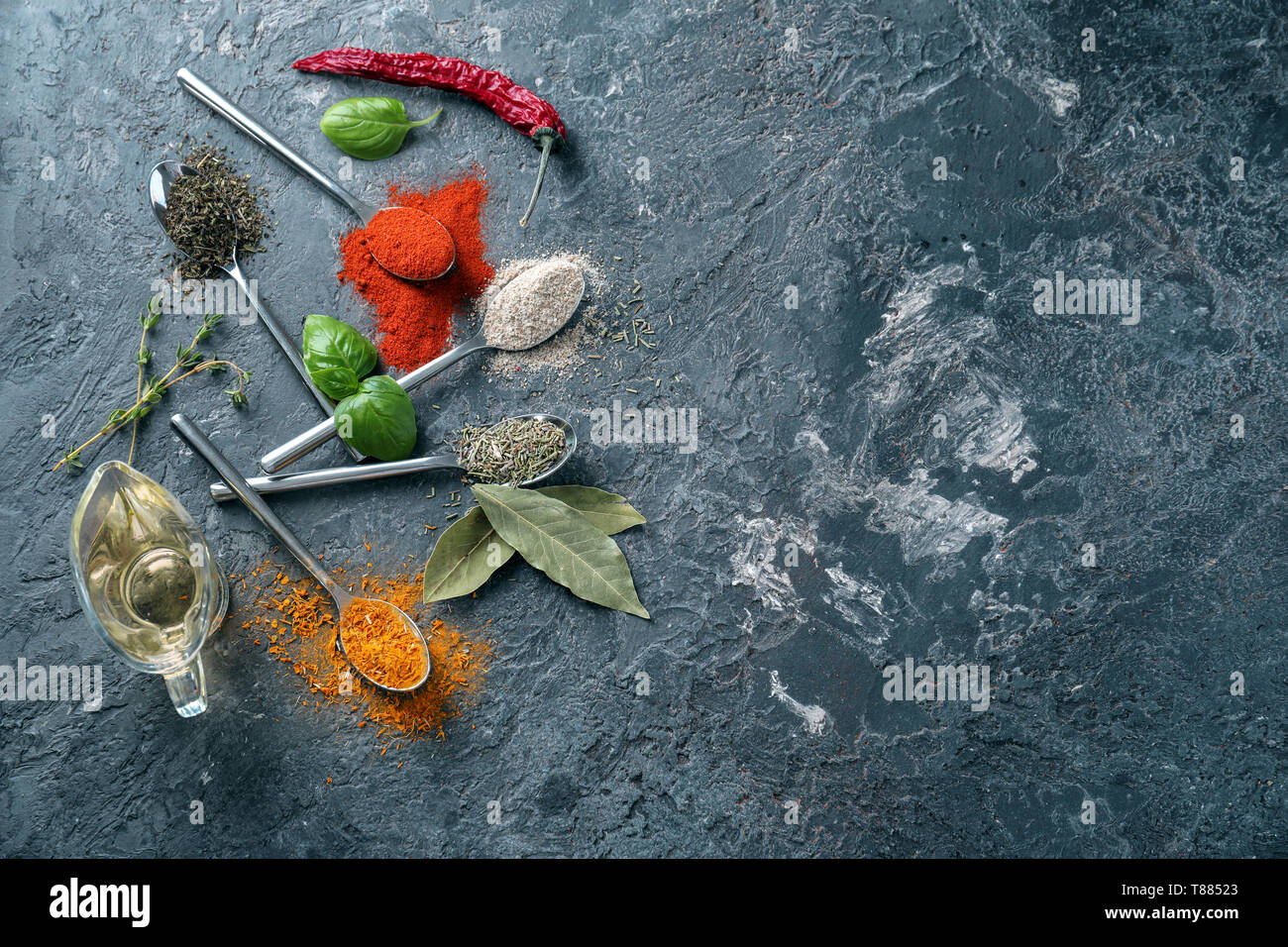 Different kinds of spices with oil on grey background Stock Photo - Alamy