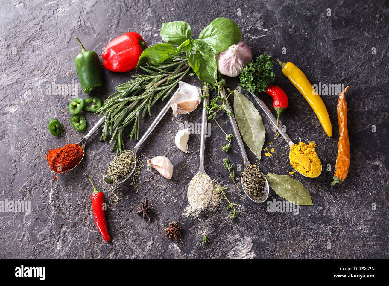 Different kinds of spices with herbs on grey background Stock Photo - Alamy