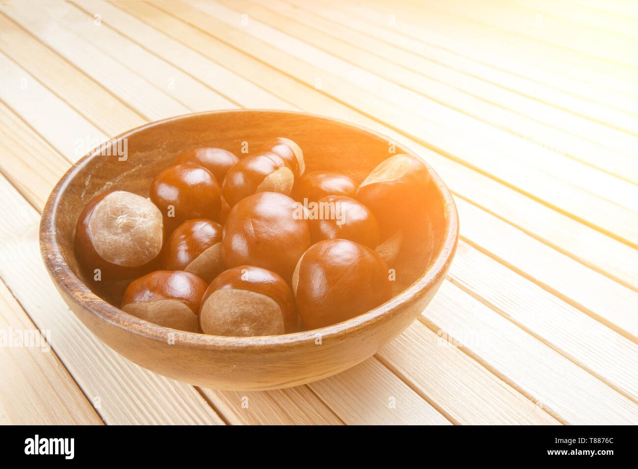 Chestnuts in wooden bowl in rays of morning sun Stock Photo - Alamy