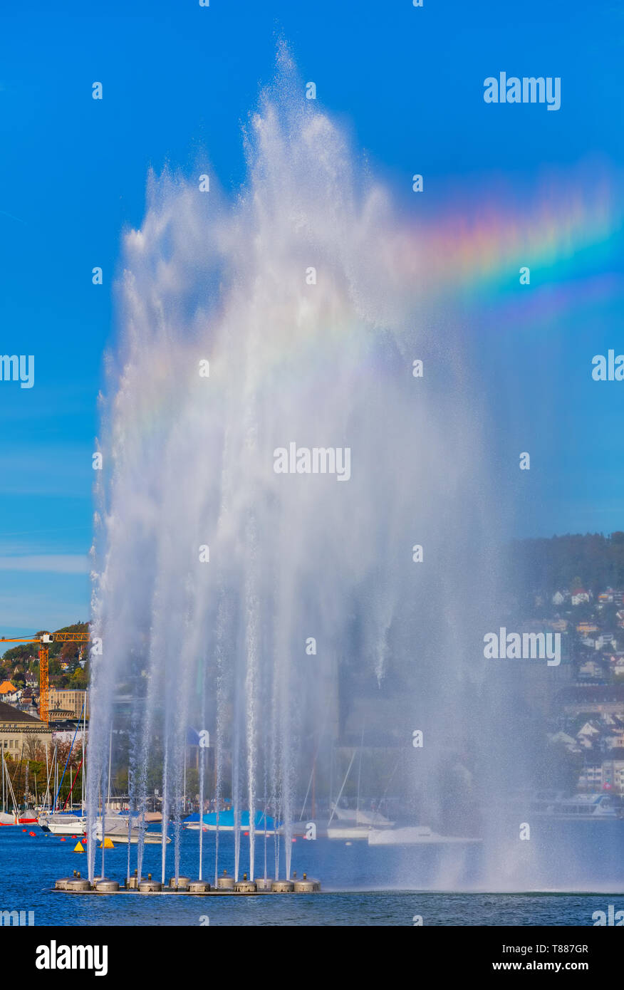 A fountain and boats on Lake Zurich in Switzerland, buildings of the ...