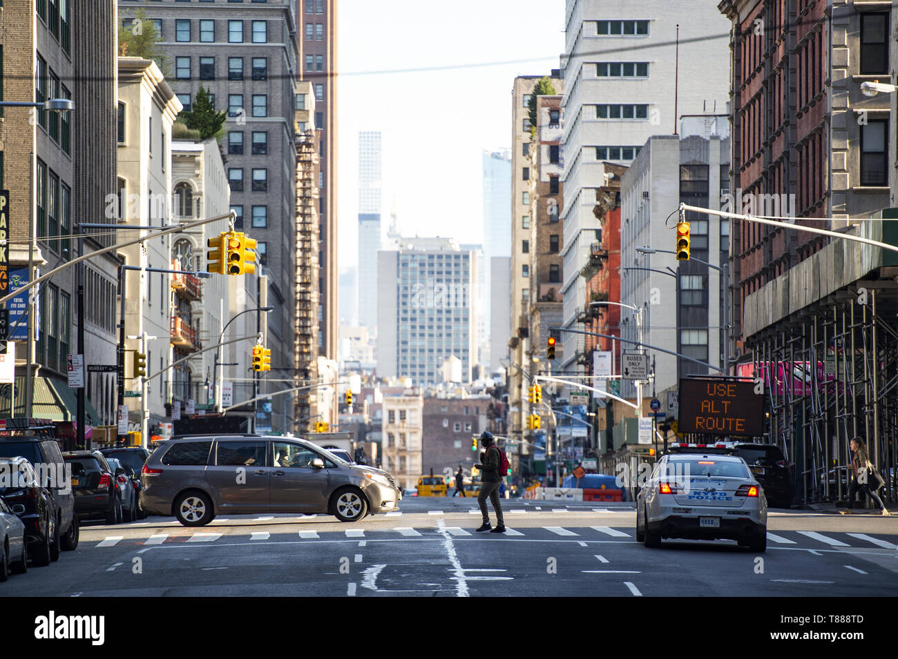Street traffic on the streets of Manhattan with people crossing a busy ...