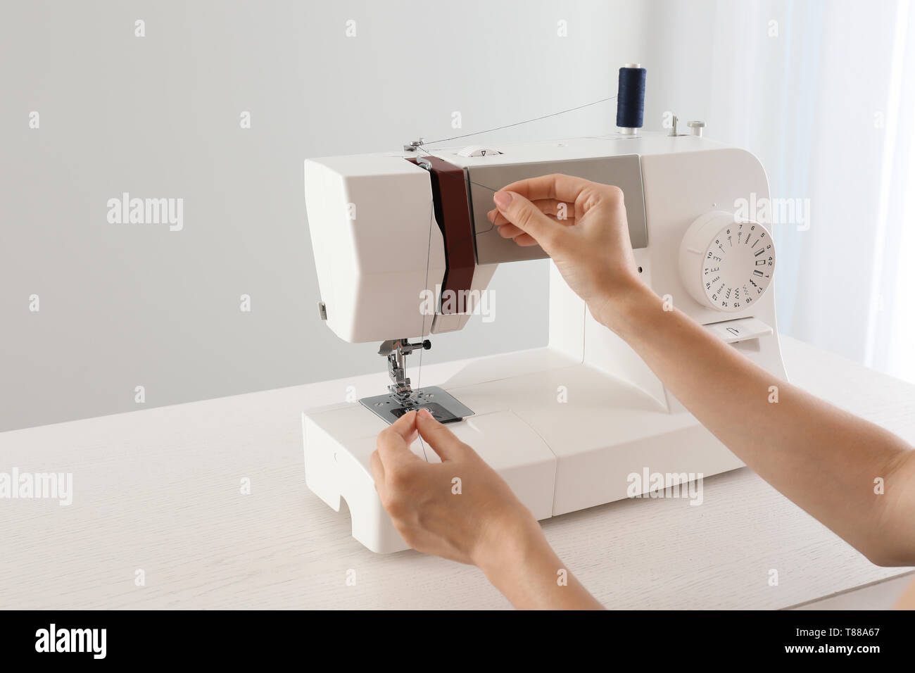 Female tailor threading sewing machine indoors Stock Photo - Alamy