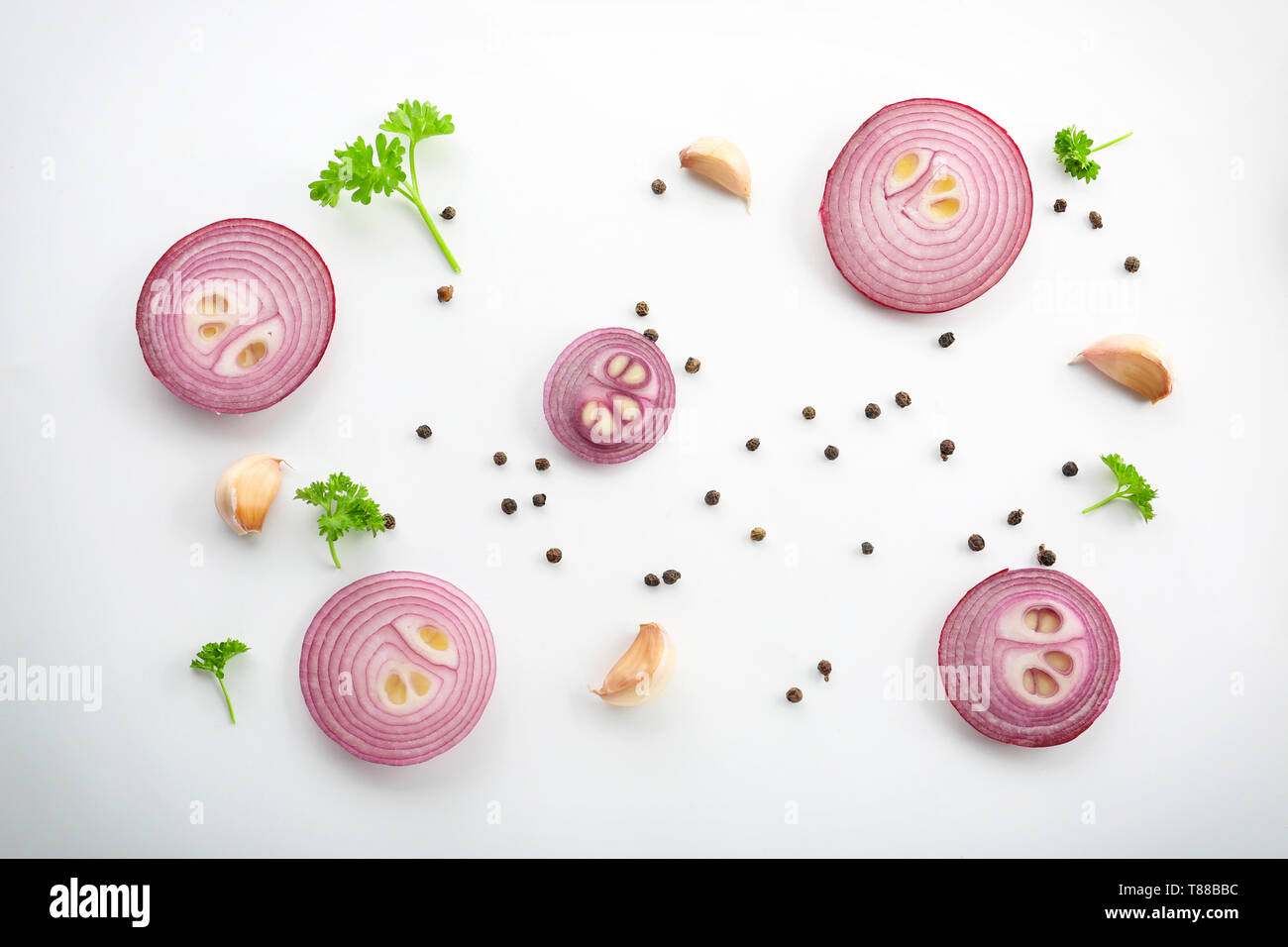 Composition with sliced red onion, garlic and spices on white ...