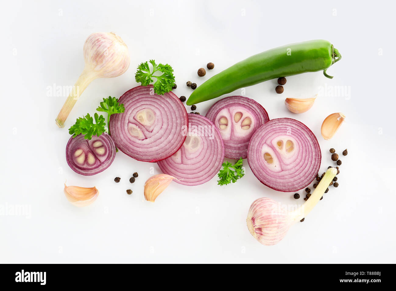 Composition with sliced red onion, garlic and spices on white ...