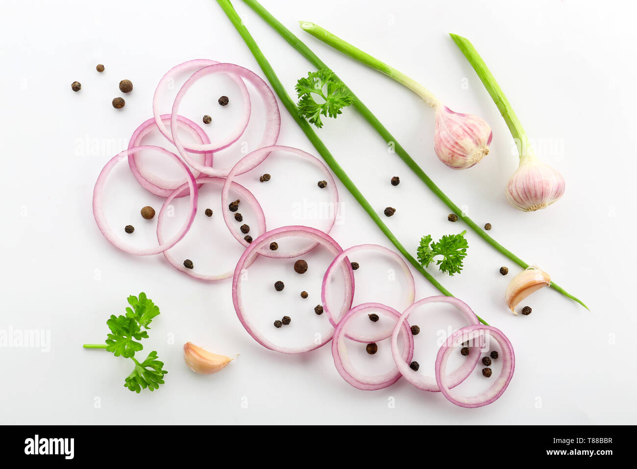 Composition with sliced red onion, garlic and spices on white ...