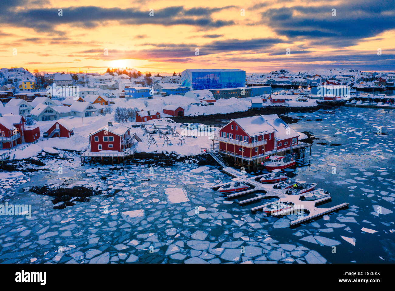 Sunrise over the icy sea and fishing village of Ballstad, Vestvagoy ...