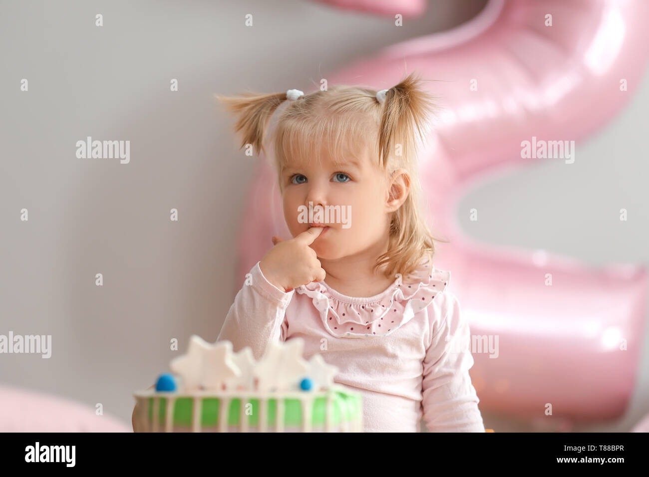Cute little girl with delicious birthday cake sitting at home Stock ...