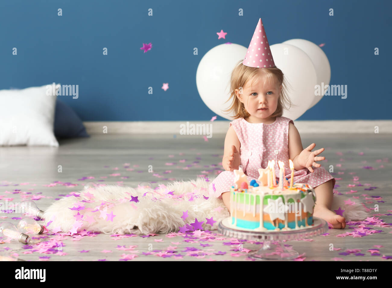 Cute little girl with birthday cake sitting on fluffy rug indoors Stock ...