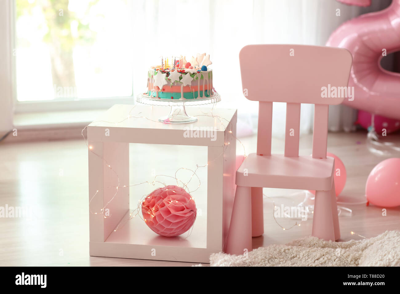 Stand with birthday cake on table in children room Stock Photo - Alamy