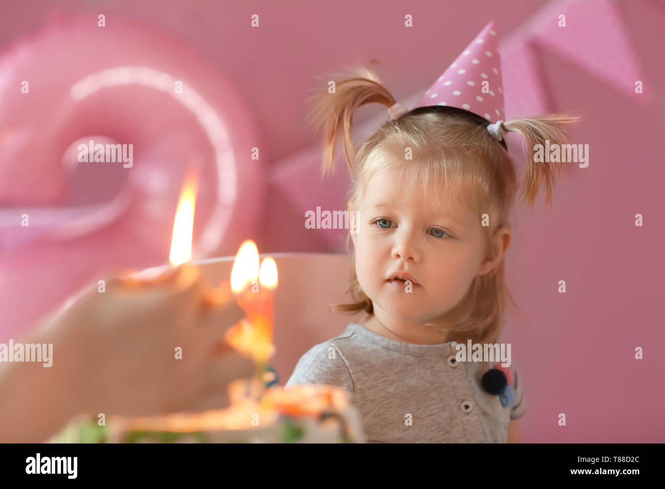 Cute little girl with birthday cake sitting on chair in room Stock ...