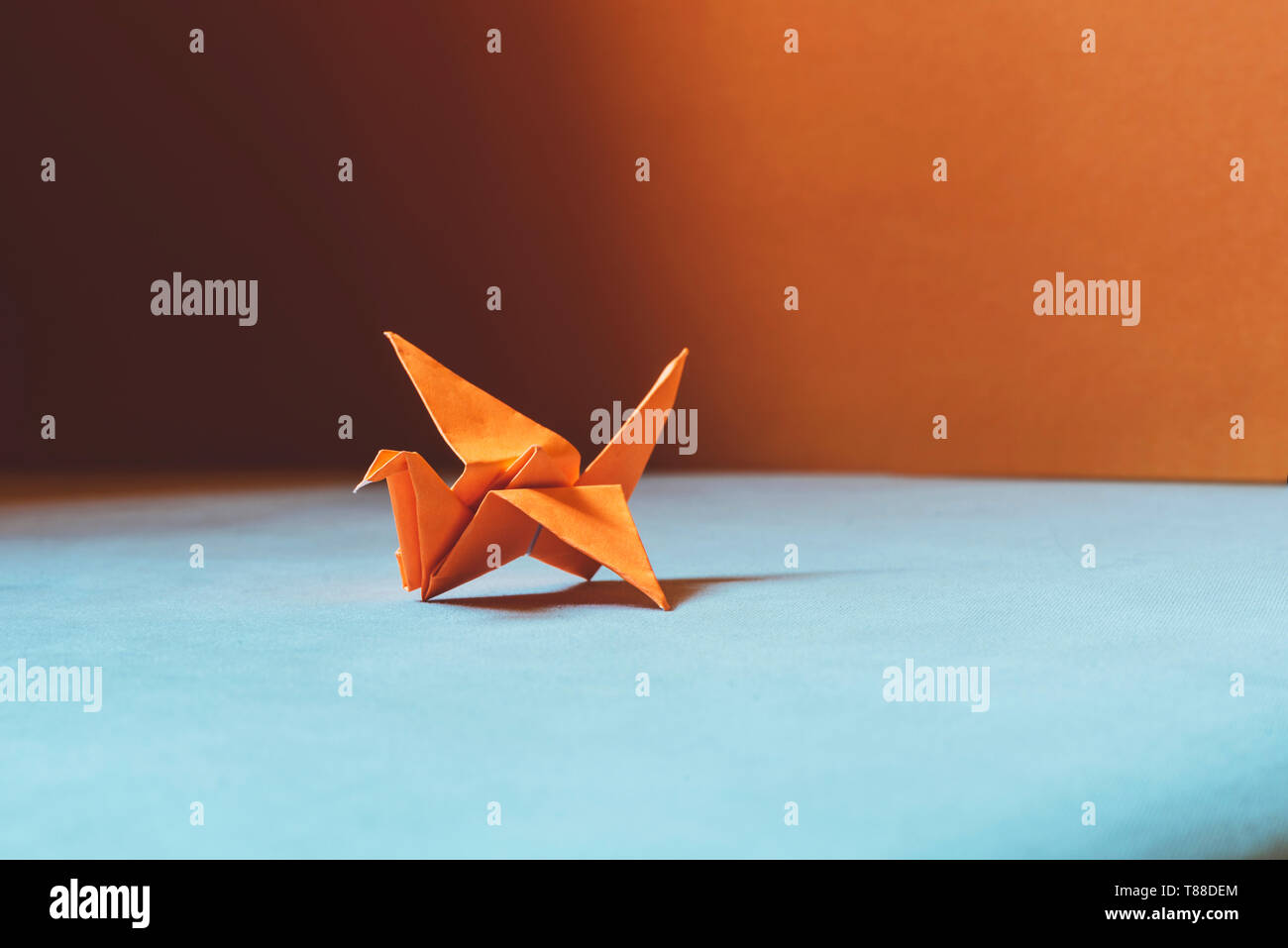 Orange origami bird, a bird made of paper-origami. (Soft focus), on ...