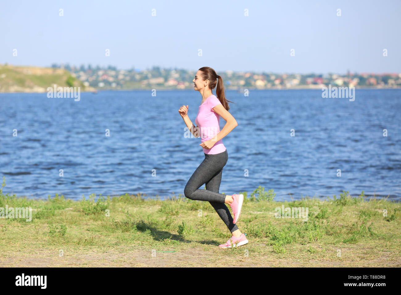 Beautiful young woman running outdoors Stock Photo - Alamy