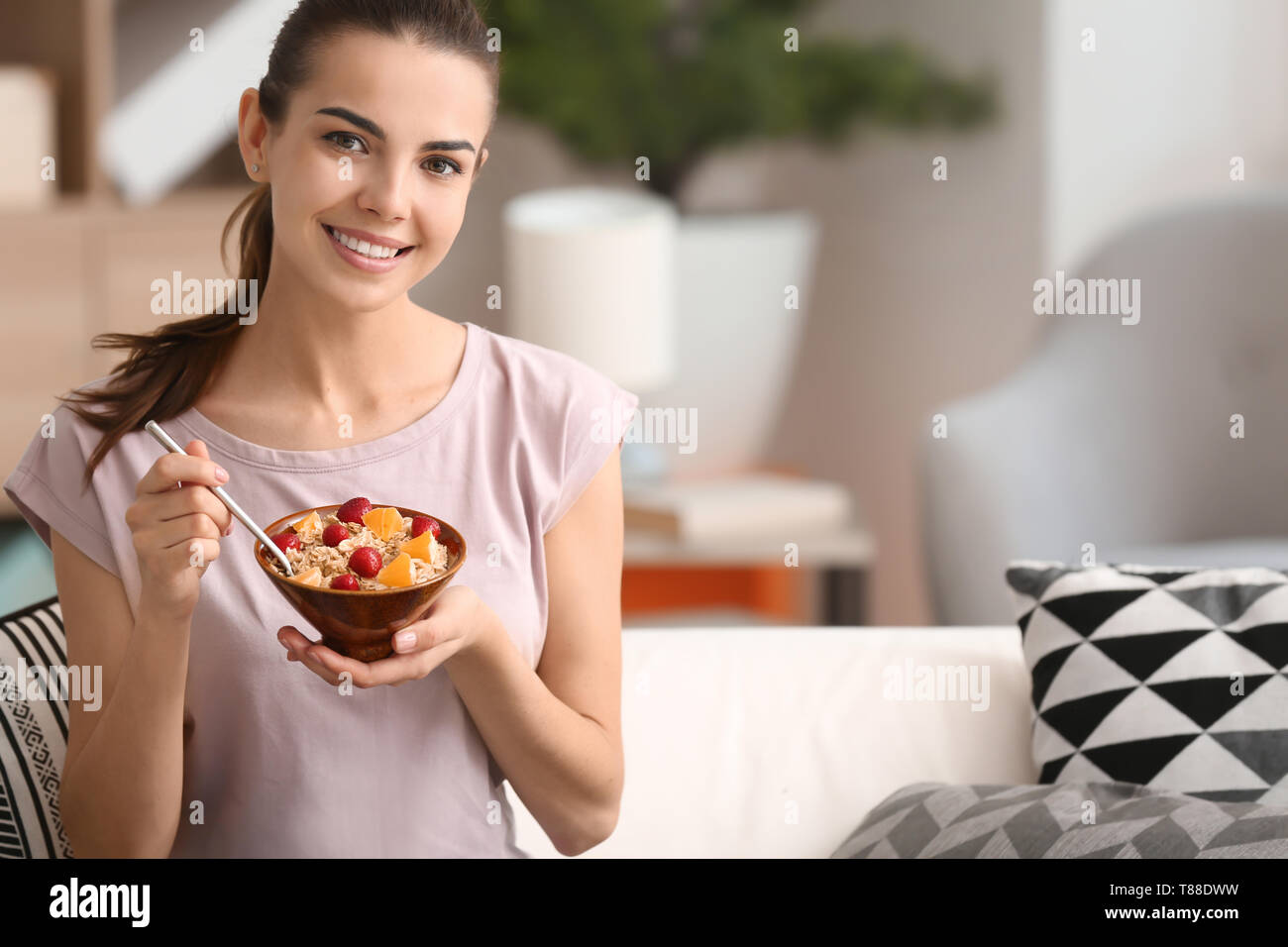 Young woman eating oatmeal porridge hi-res stock photography and images ...