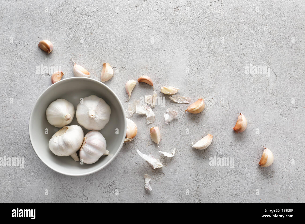 Bowl with fresh garlic on grey textured background Stock Photo - Alamy