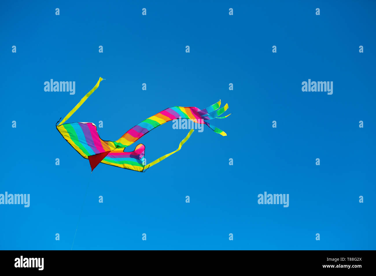 Colorful kite drifting in blue sky Stock Photo - Alamy