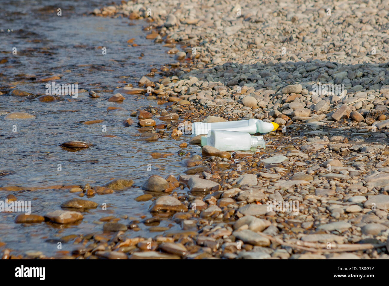 River pollution near the shore, garbage near the river, plastic food ...