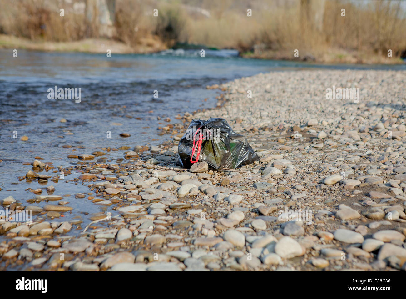 River pollution near the shore, garbage pack near the river, plastic ...