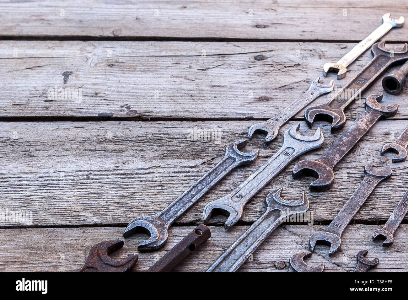 Metal wrench rusty tools lying on a black wooden table. Hammer, chisel ...