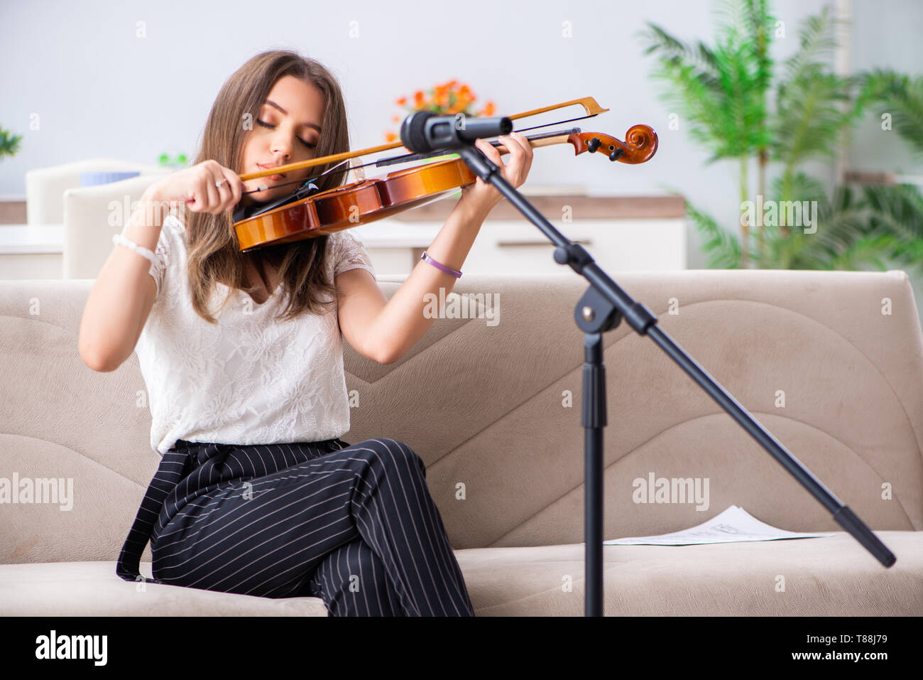 Female beautiful musician playing violin at home Stock Photo - Alamy