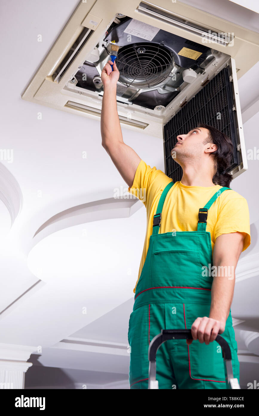 Young repairman repairing ceiling air conditioning unit Stock Photo - Alamy