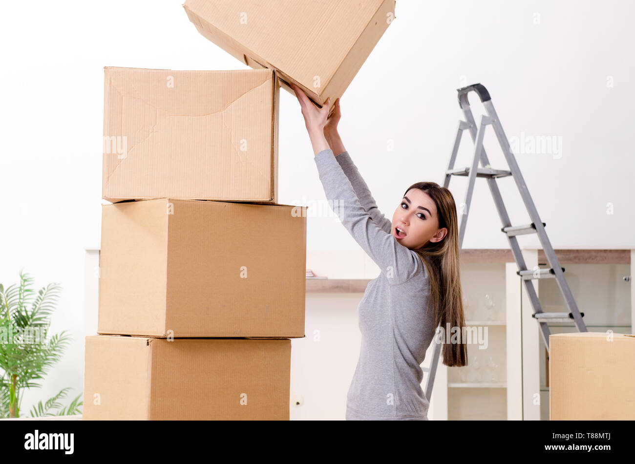 Young beautiful woman moving to new flat Stock Photo - Alamy