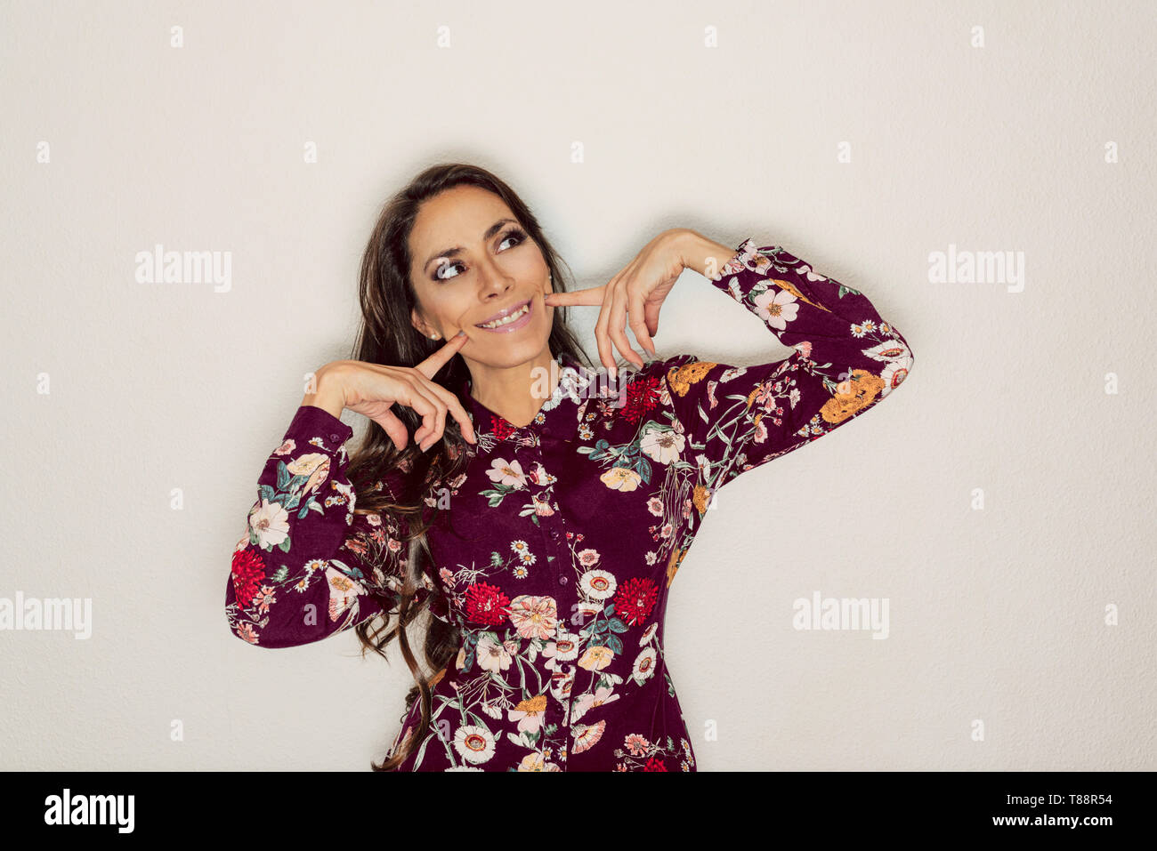 Beautiful woman pointing cheek hi-res stock photography and images - Alamy