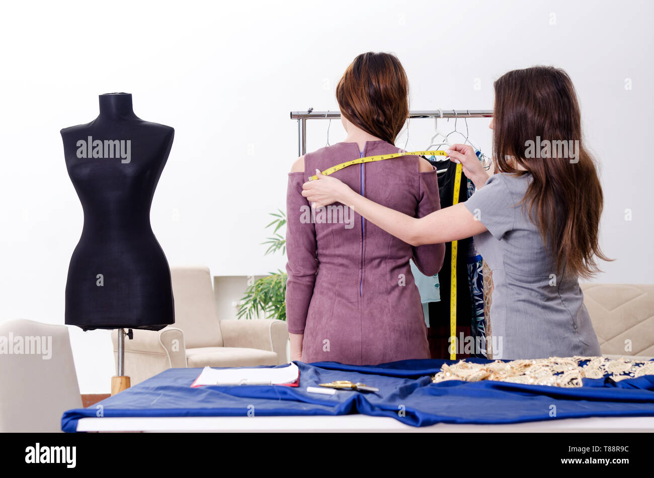Young beautiful female tailor taking measurements Stock Photo - Alamy