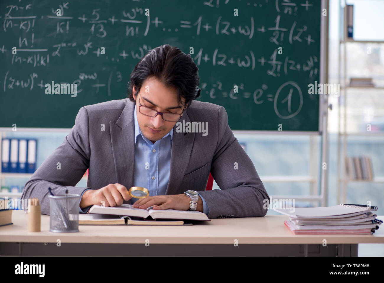 Young handsome math teacher in classroom Stock Photo - Alamy