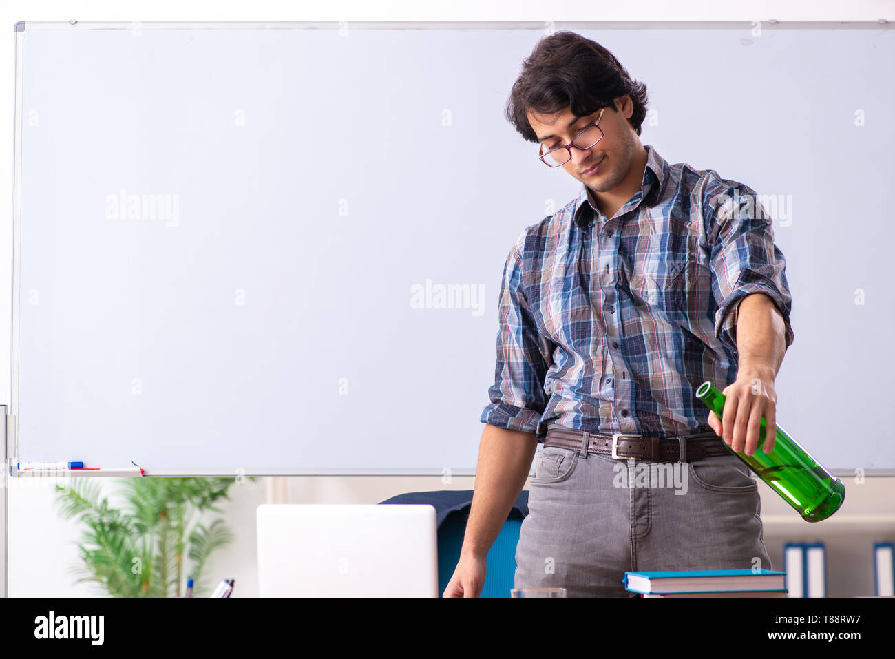 Male teacher drinking in the classroom Stock Photo - Alamy