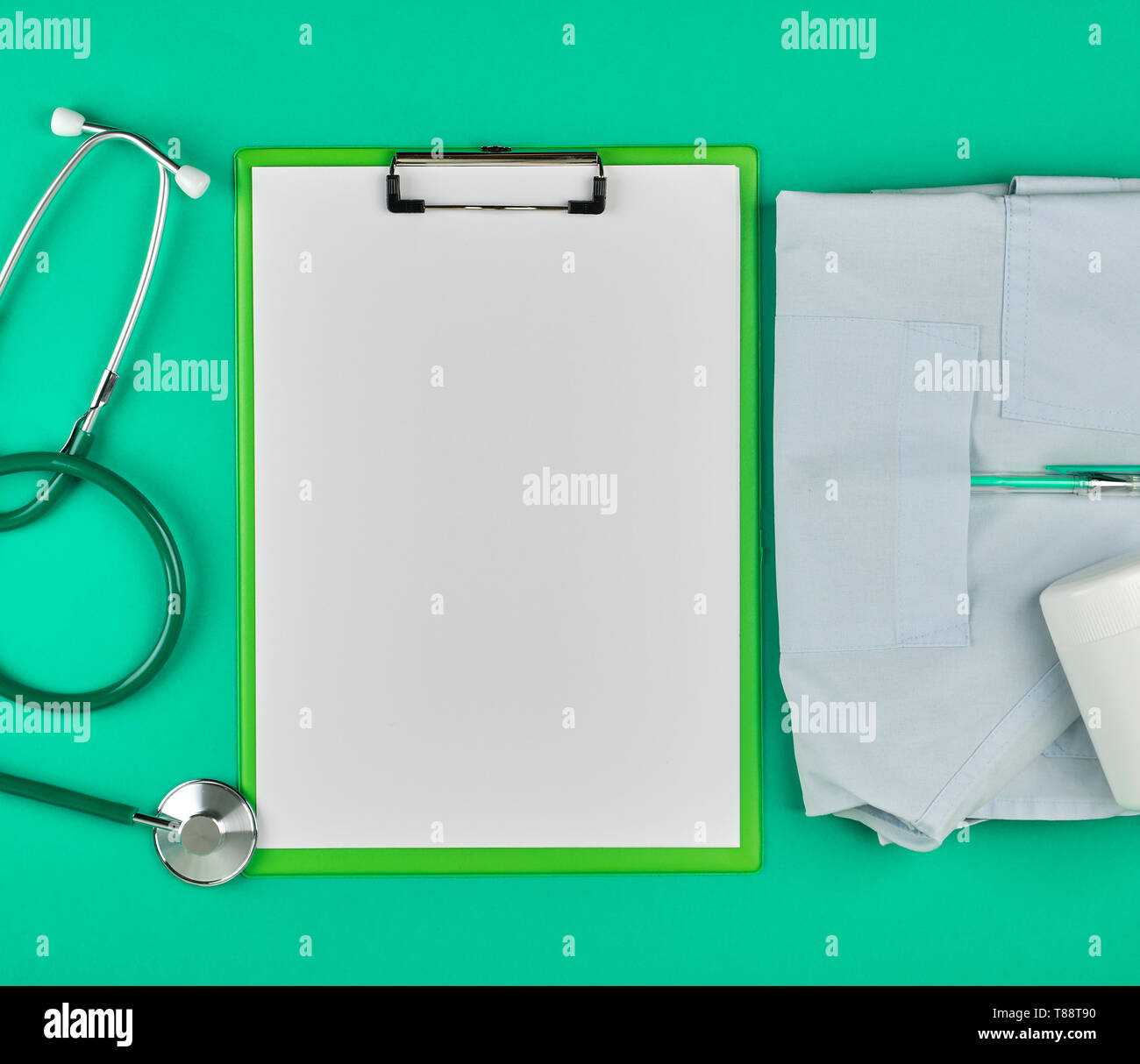 empty white sheets and a medical stethoscope on a green background ...
