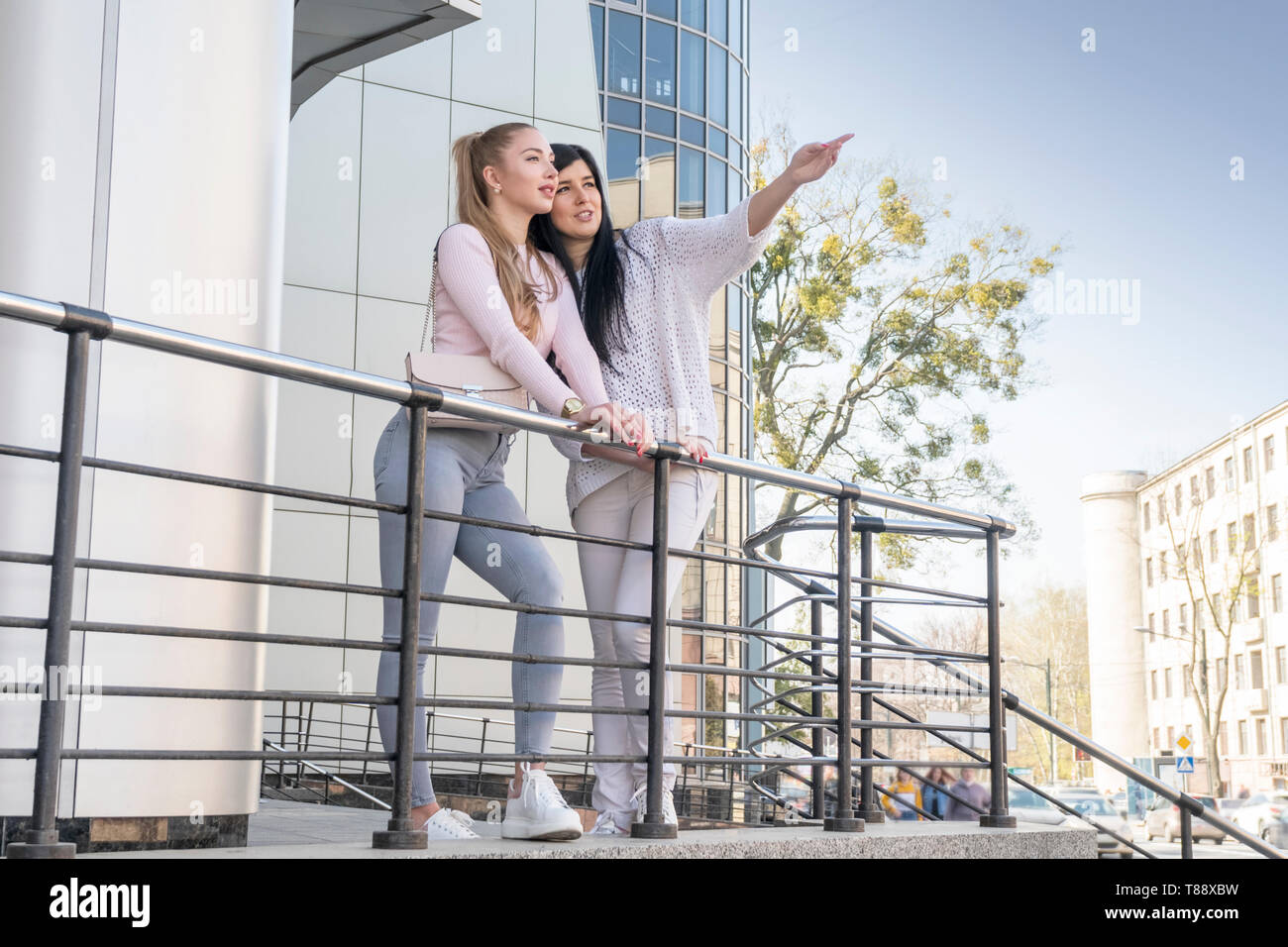 woman points her friend with a finger into the distance, standing at ...