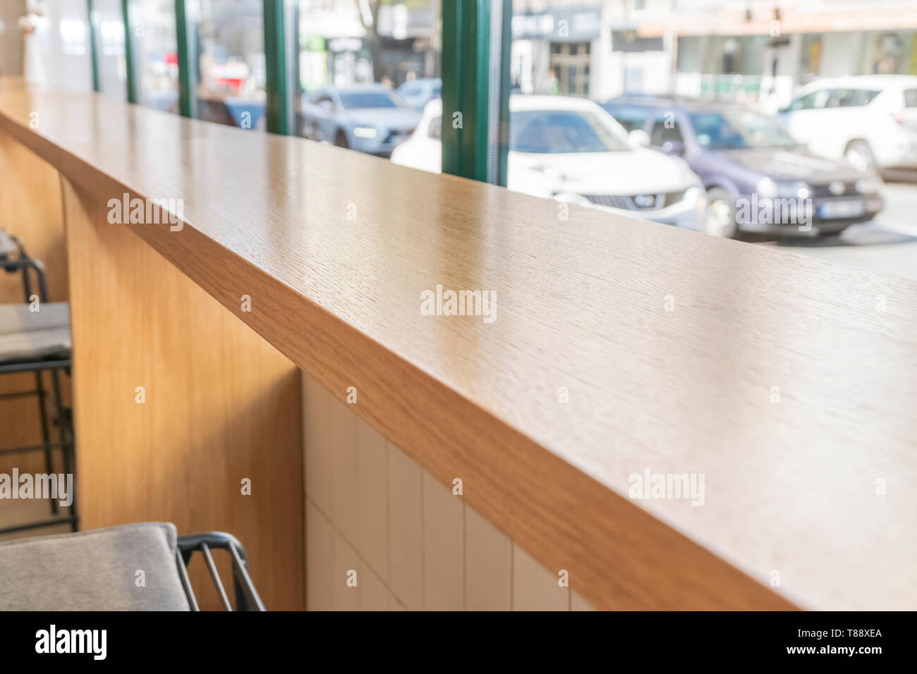 long wooden table in a cafe by the window overlooking the street with ...