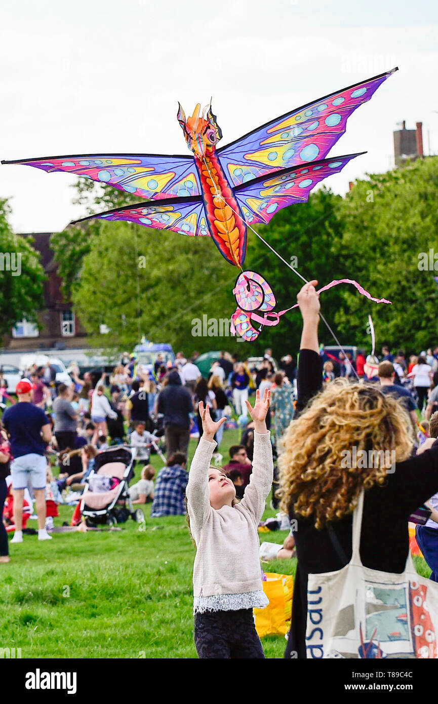 London, UK. 12 May 2019. A girl, undeterred by a lack of wind, attempts ...