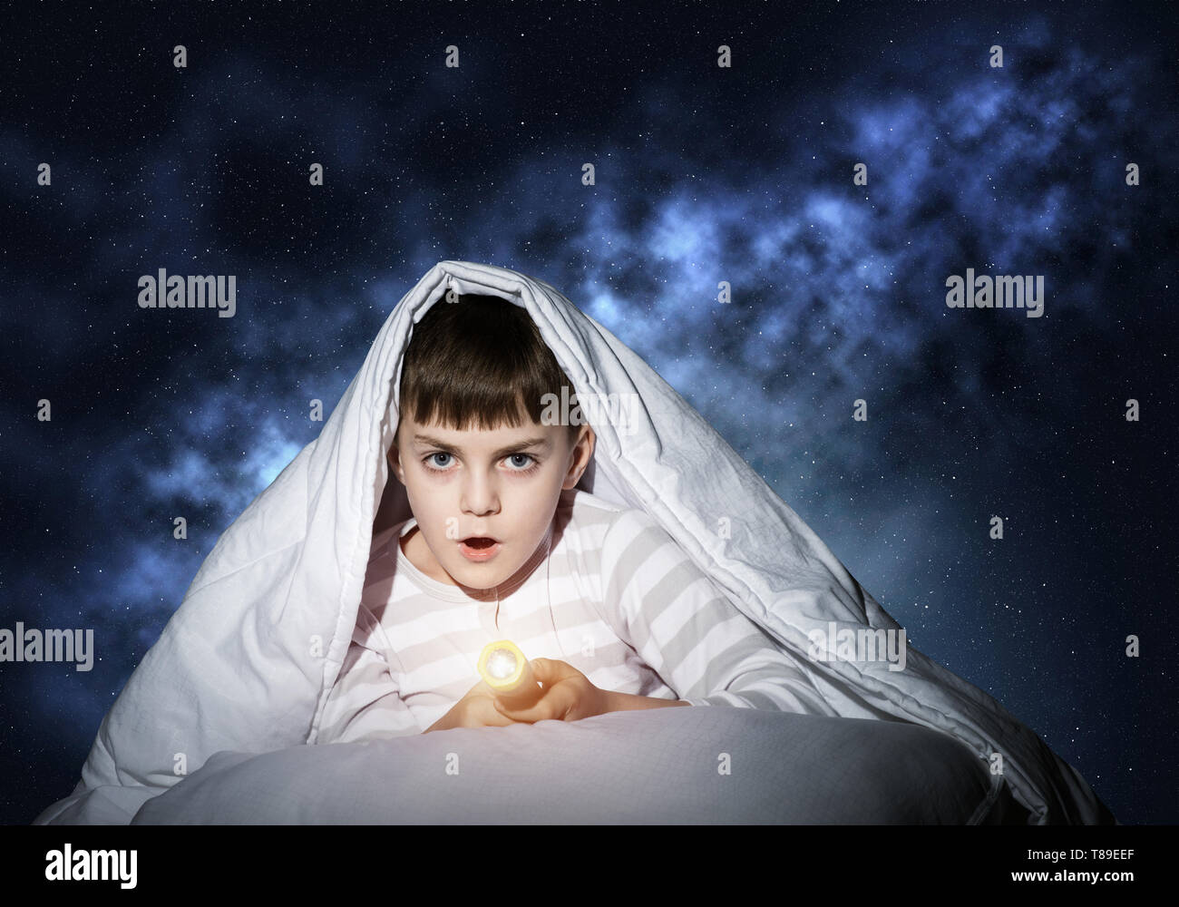 Surprised child hiding under blanket Stock Photo - Alamy