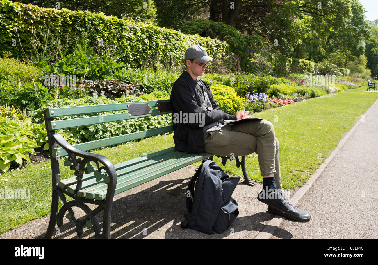 Sitting cross legged on a park bench hi-res stock photography and ...