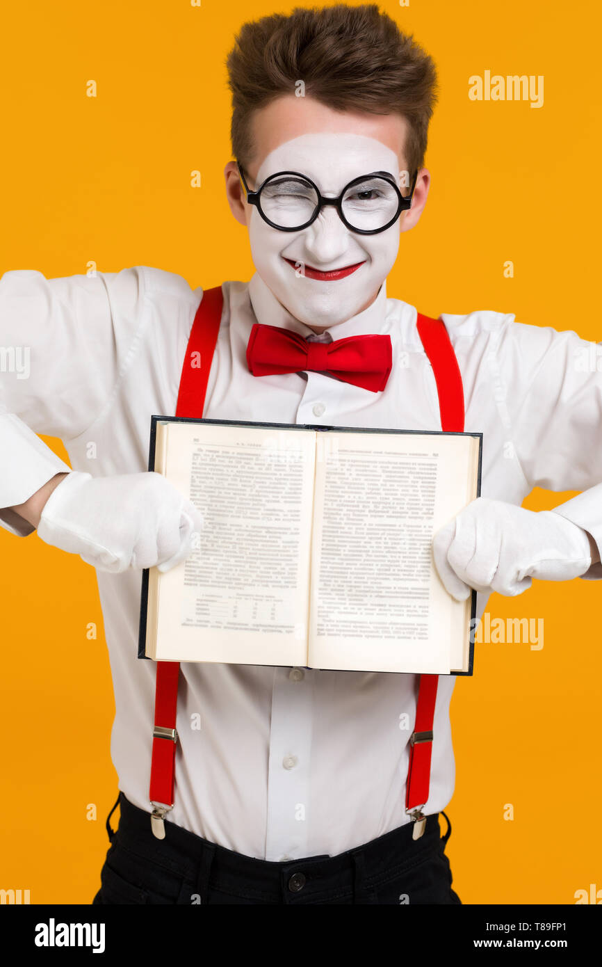portrait of mime man artist with book ape isolated on yellow background ...