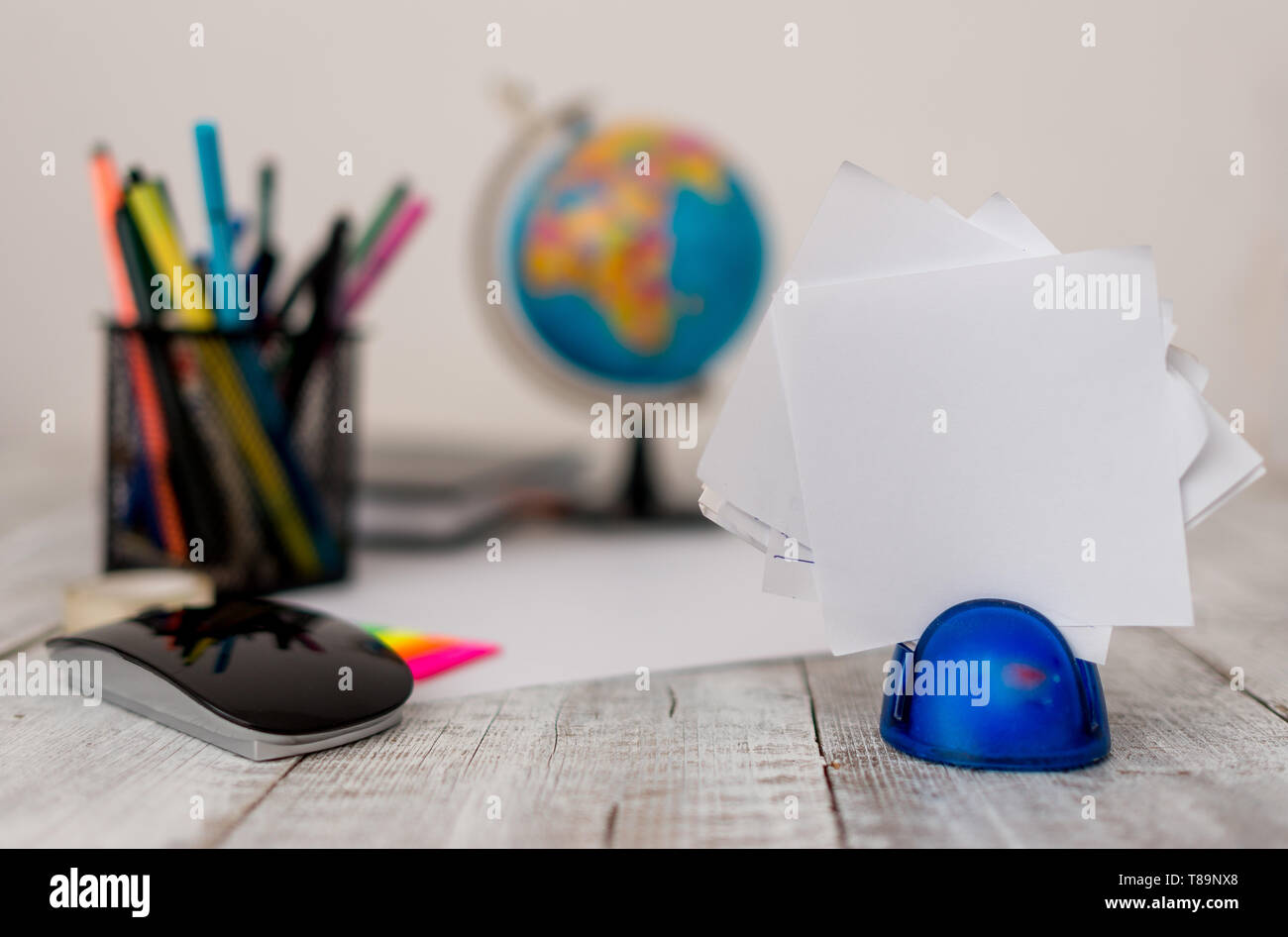 Stationary and computer stuffs with artificial globe on the wooden desk ...