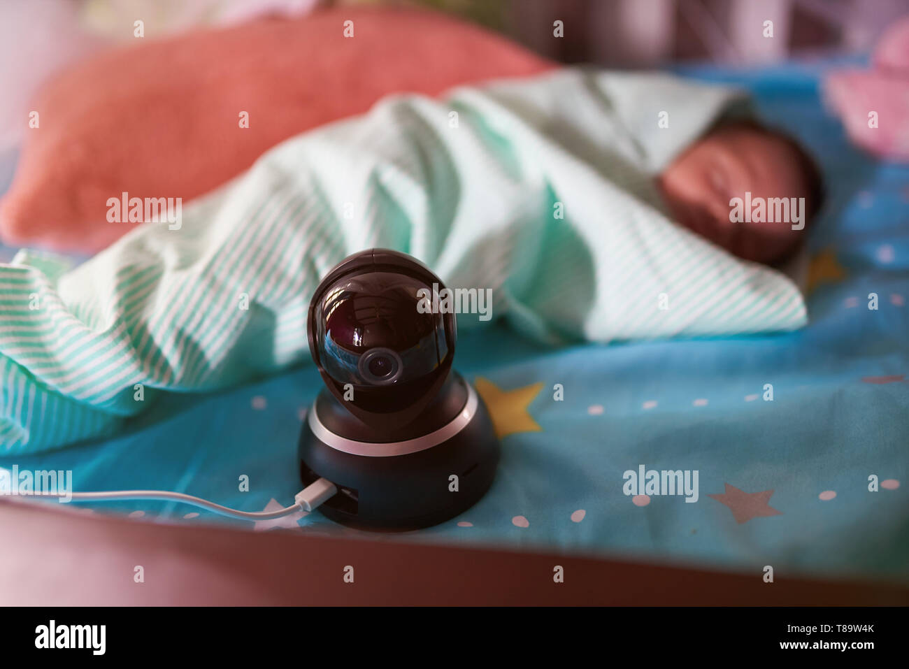 Keeping safe sleep of baby with dome home camera Stock Photo - Alamy