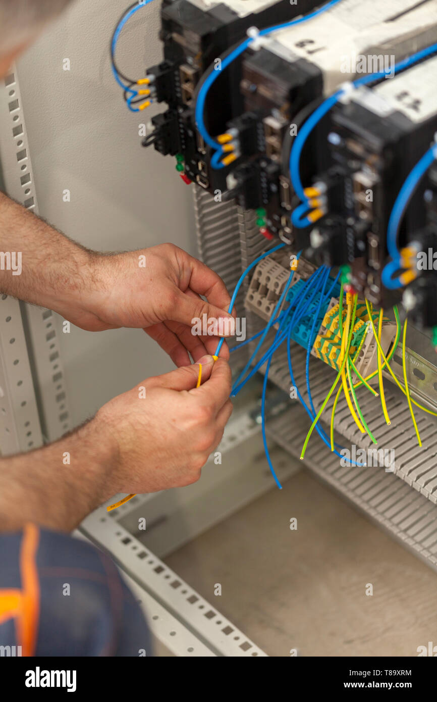 electrician connecting wire on the control panel, close up Stock Photo ...
