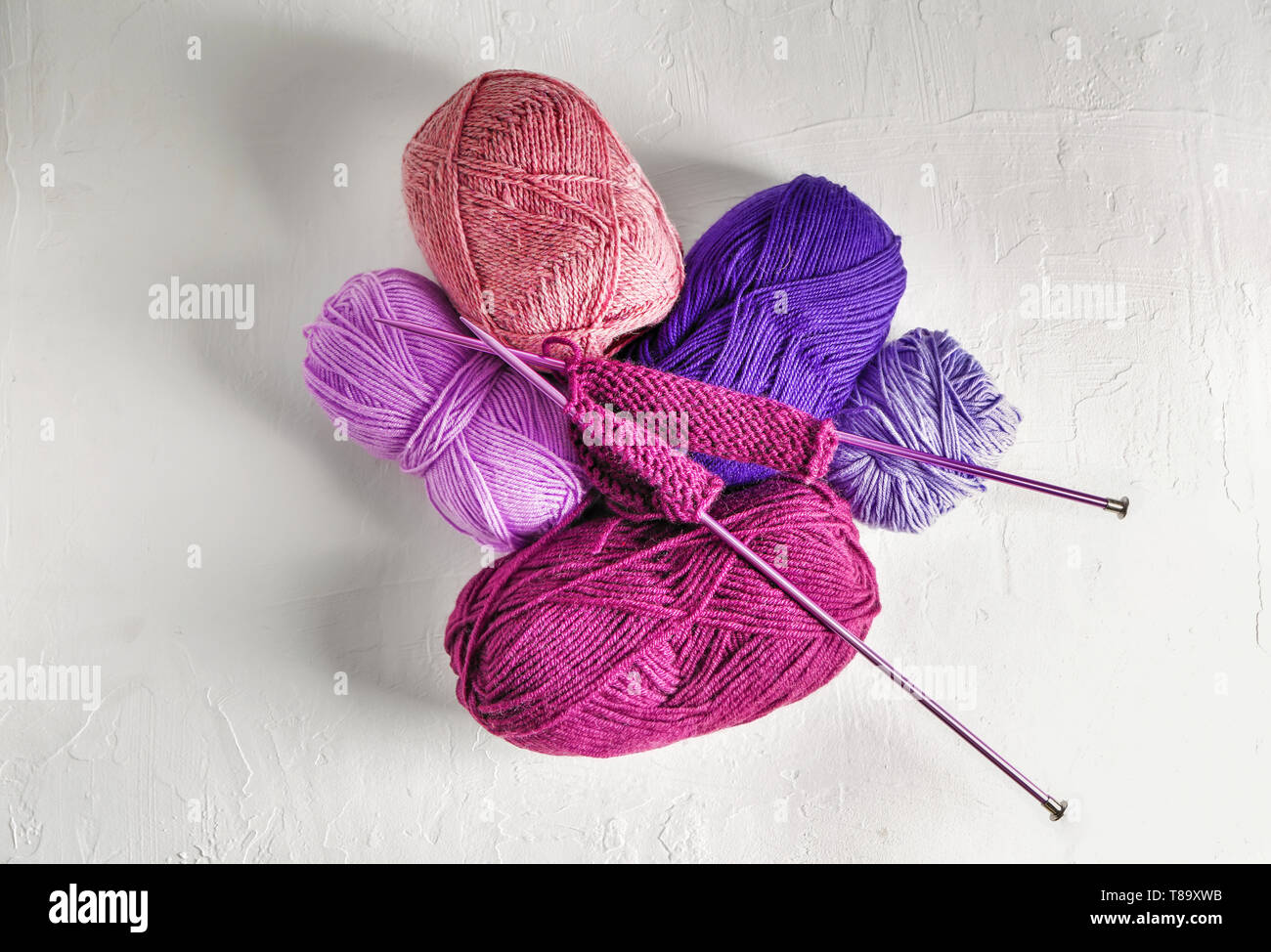 Color knitting yarn with needles on light background Stock Photo - Alamy