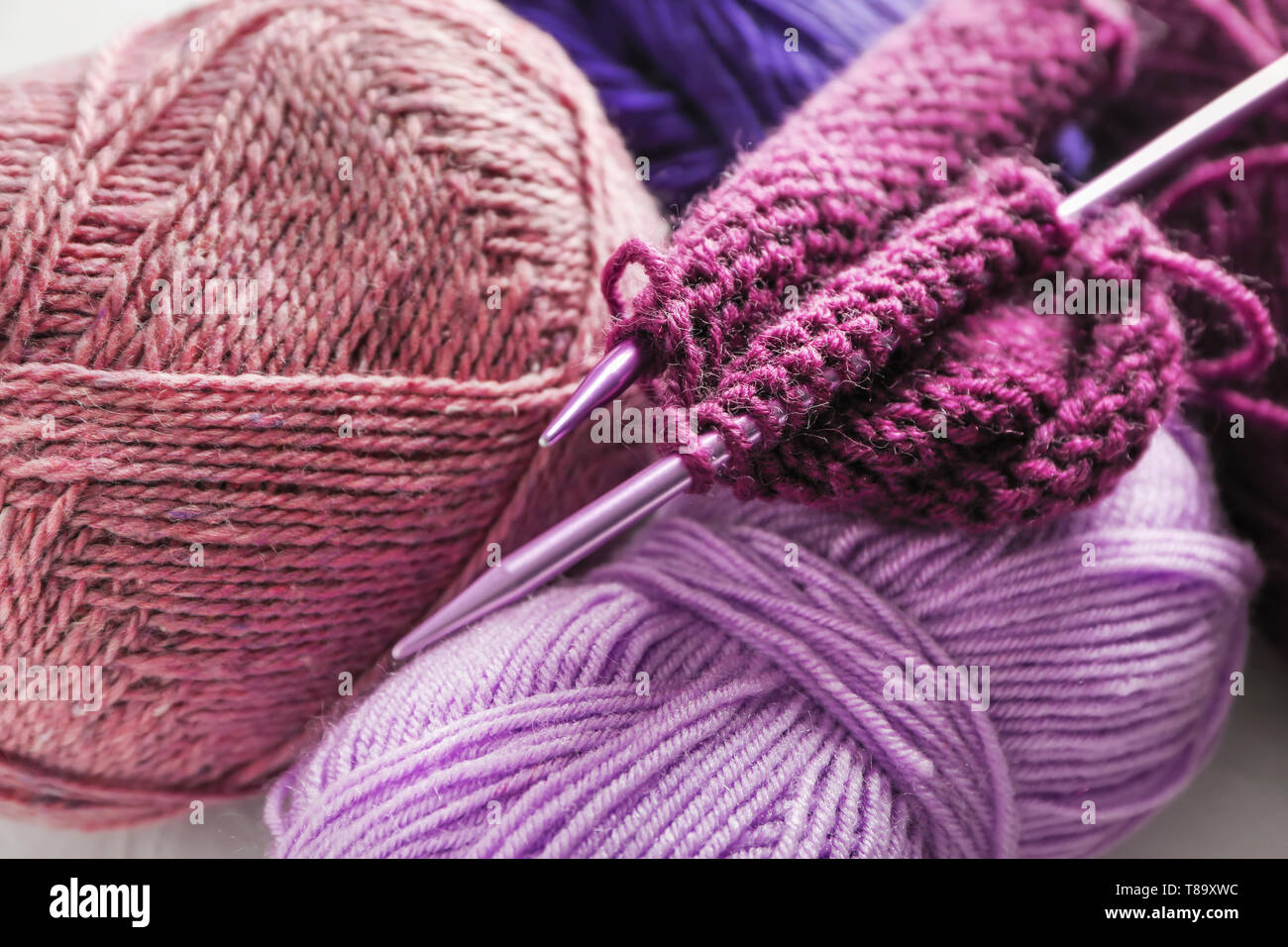 Knitting yarn with needles and unfinished clothes, closeup Stock Photo ...
