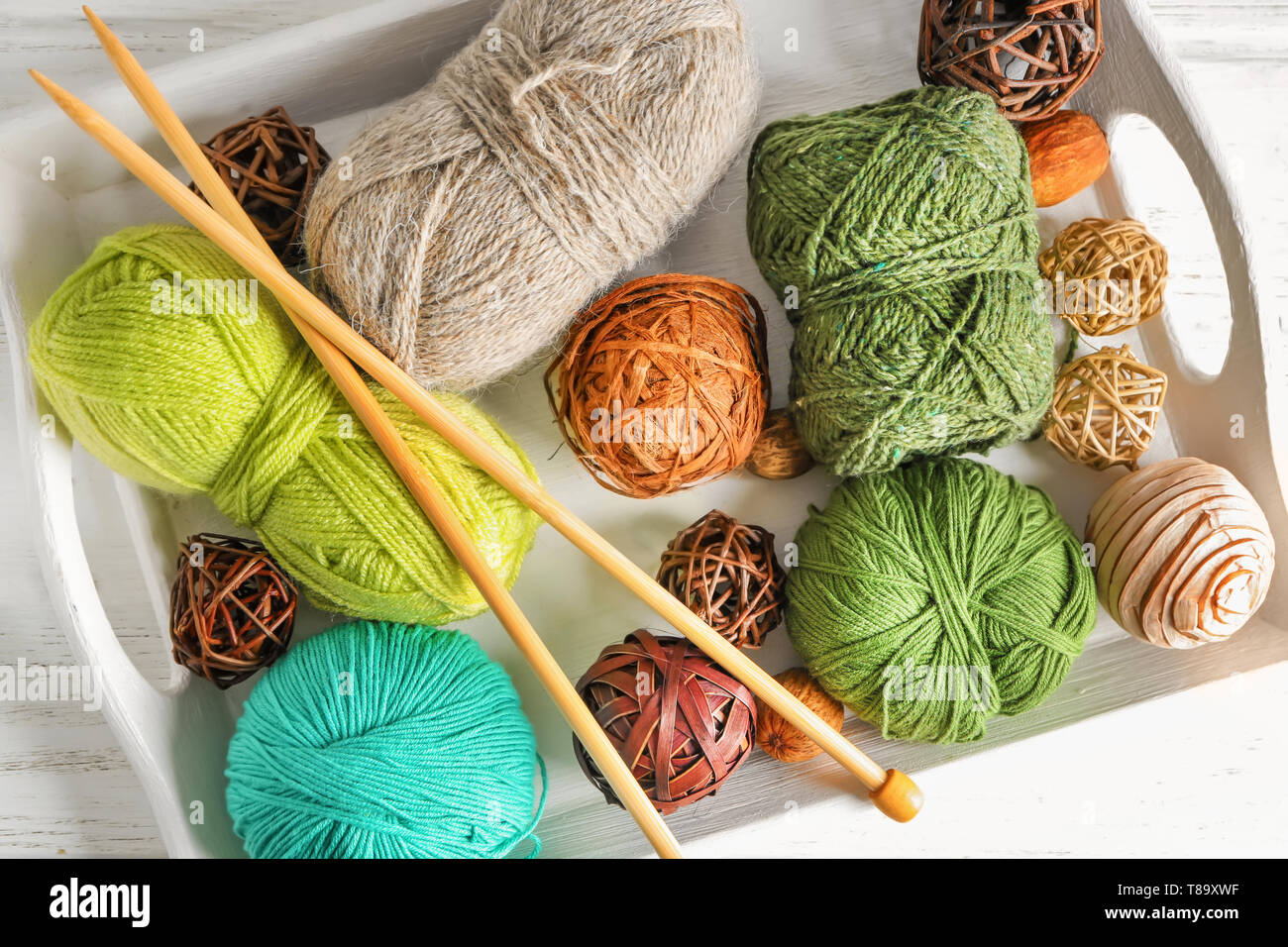 Tray with different knitting yarn and needles on table Stock Photo - Alamy