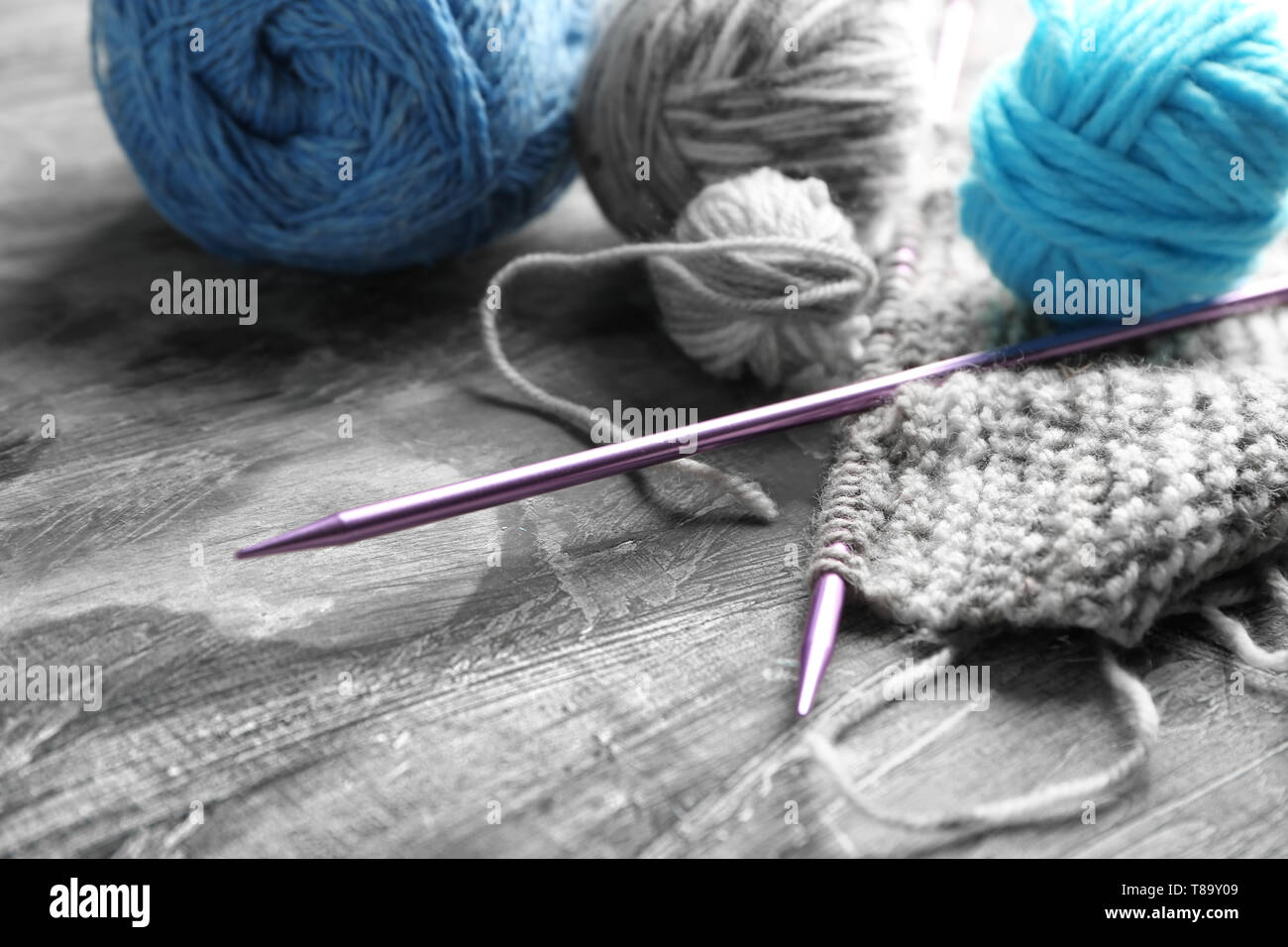 Colorful knitting yarn with unfinished clothes on table Stock Photo - Alamy